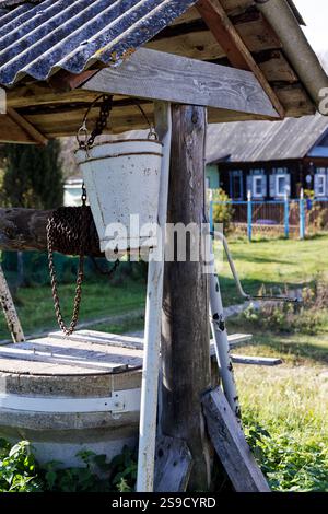 A detailed view of a rustic village well featuring a weathered metal ...