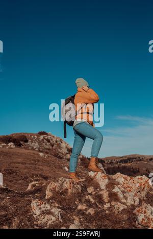 Cheering woman backpacker enjoy the view on sunrise mountain top cliff ...