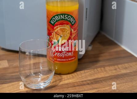Bottle of orange and mango squash and empty glass Stock Photo - Alamy