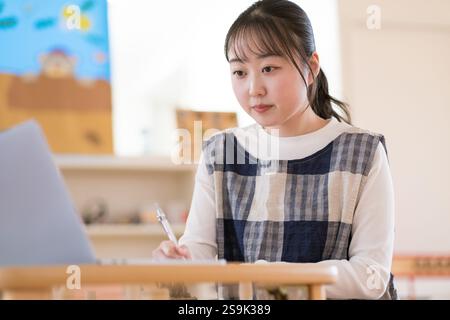 Childcare worker writing in a journal Stock Photo - Alamy