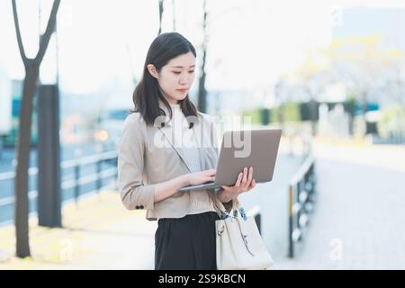 Woman operating a laptop outdoors Stock Photo - Alamy