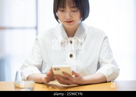 Woman operating smartphone in room Stock Photo - Alamy