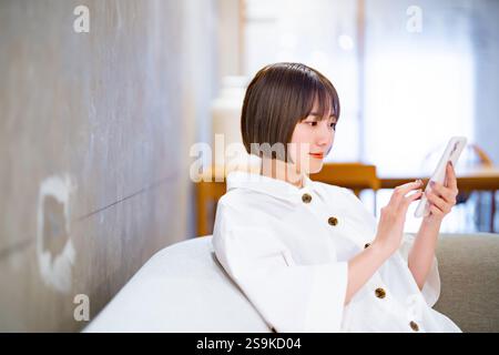 Woman operating smartphone in room Stock Photo - Alamy