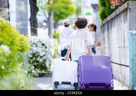 Boy pulling suitcase travel Stock Photo - Alamy