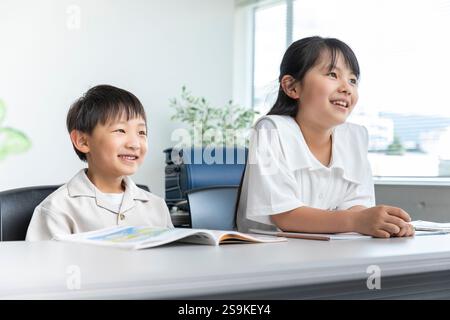 Primary schools students studying in a classroom Stock Photo - Alamy