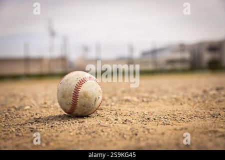 Baseball ball rolling on the ground Stock Photo - Alamy