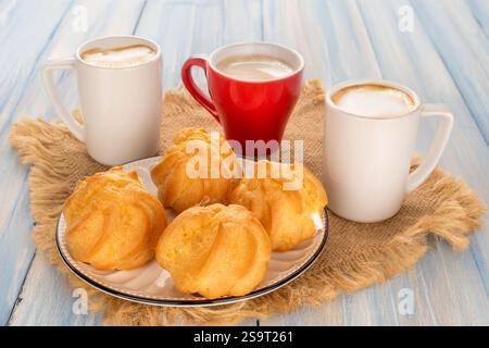 Napkin with tasty eclairs on wooden table, closeup Stock Photo - Alamy