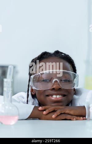 Scientist hiding behind table with petri dish and flask analyzing ...