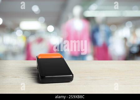Payment terminal on wooden counter in store Stock Photo - Alamy