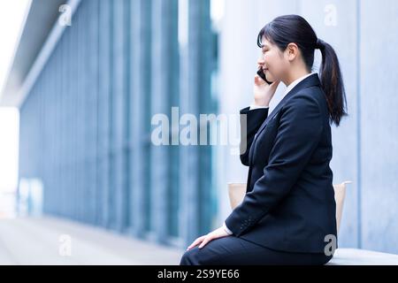 Newly graduated woman sitting on bench Stock Photo - Alamy