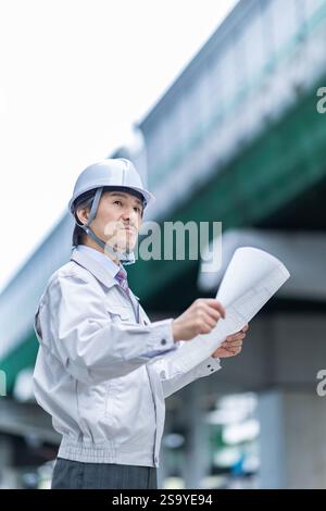 Man looking at blueprints Stock Photo - Alamy