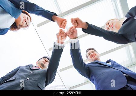 A team of businesspeople overlapping members' hands to strengthen unity ...