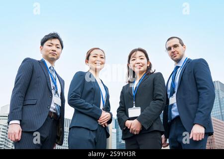 Business team of four lined up under blue sky Stock Photo - Alamy