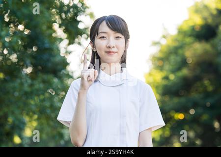Woman in white coat striking a pointing pose Stock Photo - Alamy