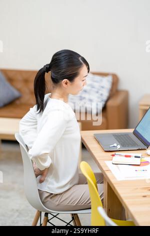 Woman suffering from back pain at work Stock Photo - Alamy