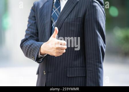 Businessman making the ‘thumbs up’ pose Stock Photo - Alamy