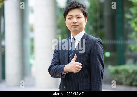 Businessman making the ‘thumbs up’ pose Stock Photo - Alamy