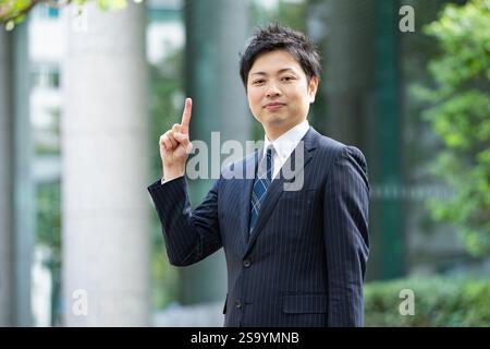 Business person posing "number one" with the index finger pointing up ...
