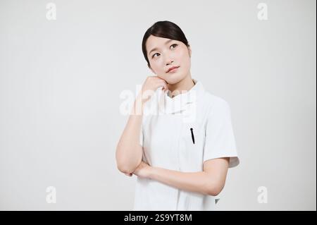 Woman in white coat in questioning pose Stock Photo - Alamy