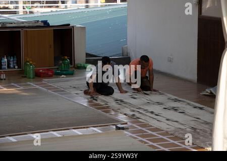 Carpet Factory workers giving a finishing touch to the carpets. Bouddha ...