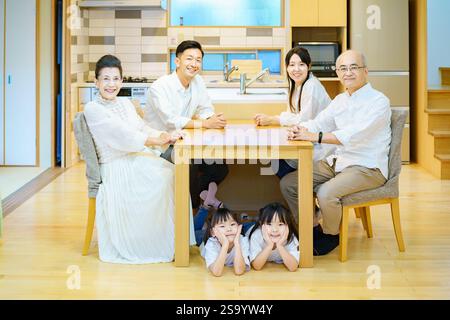 Three generations of a family gathered at a table Stock Photo - Alamy