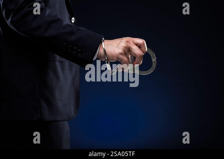 Handcuffs and male hand in suit Stock Photo - Alamy