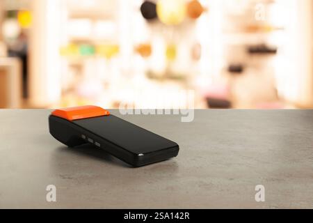 Payment terminal on grey counter in store Stock Photo - Alamy