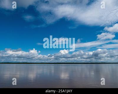 Amazon river landscape. Clouds are reflected on the huge expanse of ...