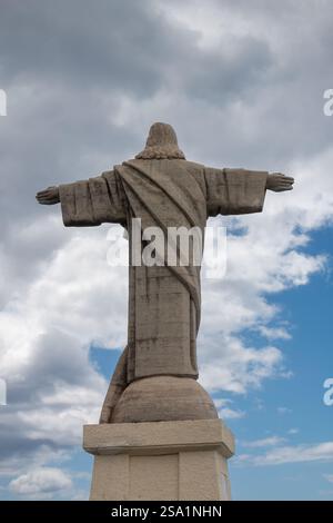 Monumental statue of Cristo Rei (Jesus Christ) on a hill at the coast ...