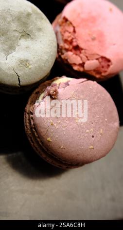 Damaged colorful macarons in close-up showing imperfections and cracks ...