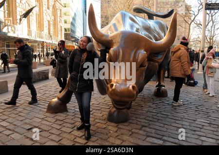 People take photos by the "Charging Bull" statue in the Financial District in Manhattan, New ...