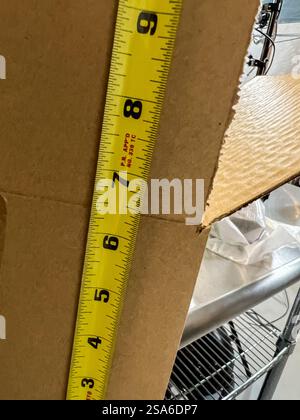 Measuring cardboard box dimensions with tape measure Stock Photo - Alamy