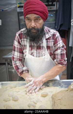 A middle aged Sikh man volunteering in the Langar communal kitchen in ...