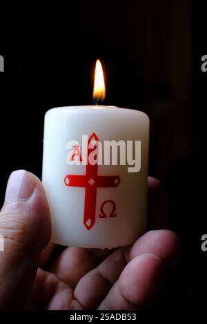 Candle lit with Alpha and Omega symbols Stock Photo - Alamy