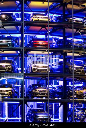 illuminated glass car silo with new cars in the evening, section ...