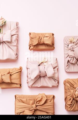 Presents wrapped in fabric scatted on pink Stock Photo - Alamy