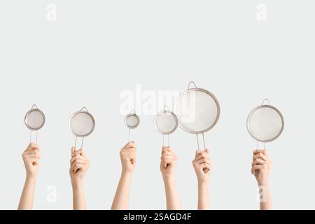 Female hands with sieves on white background Stock Photo - Alamy