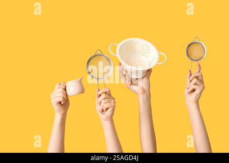 Female hands holding sieves with milk jug and measuring cup on yellow ...