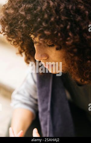 Captured in an introspective moment, this young woman, focused downward ...