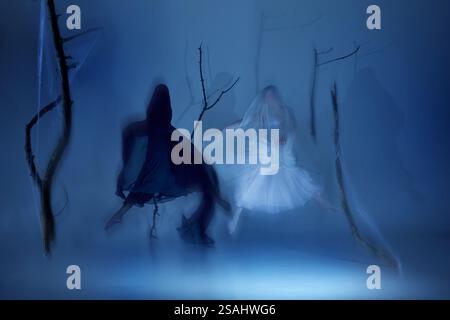 Darkness meets light. Two female ballet dancers, ghost like figures ...