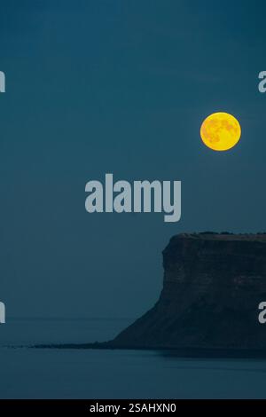 full moon rising over hunt cliff and the north sea Stock Photo - Alamy