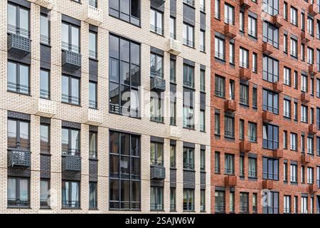 Contemporary multi-story buildings with beige, red brick and glass facades, balconies and ...