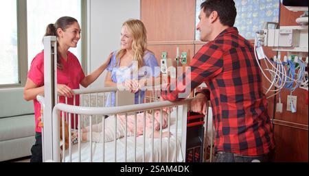 Concerned Parents Visiting Baby Daughter Lying In Hospital Cot Stock ...