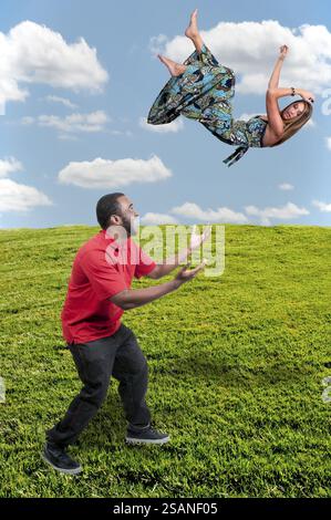 Handsome man catching a beautiful young woman falling through the sky ...