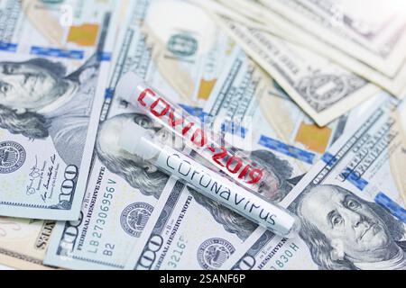 Dollar bills with test tubes labeled COVID-2019 and coronavirus ...