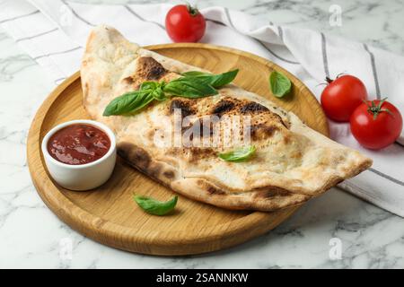 Delicious calzone served on white marble table, top view. Space for ...