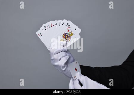 Illusionist hiding one playing card up his sleeve while showing deck on ...
