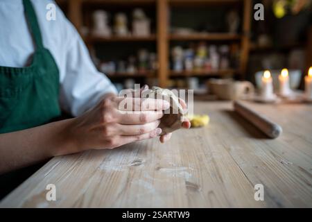 The master of sculpting pottery working in a studio. Holding a rounded ...