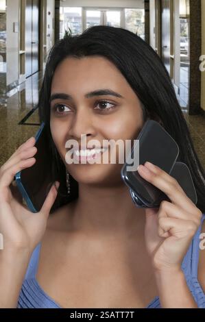 Beautiful woman talking and multitasking while juggling multiple cell ...