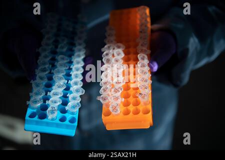 Lab tech carrying vial rack holders in a darkened science lab Stock ...